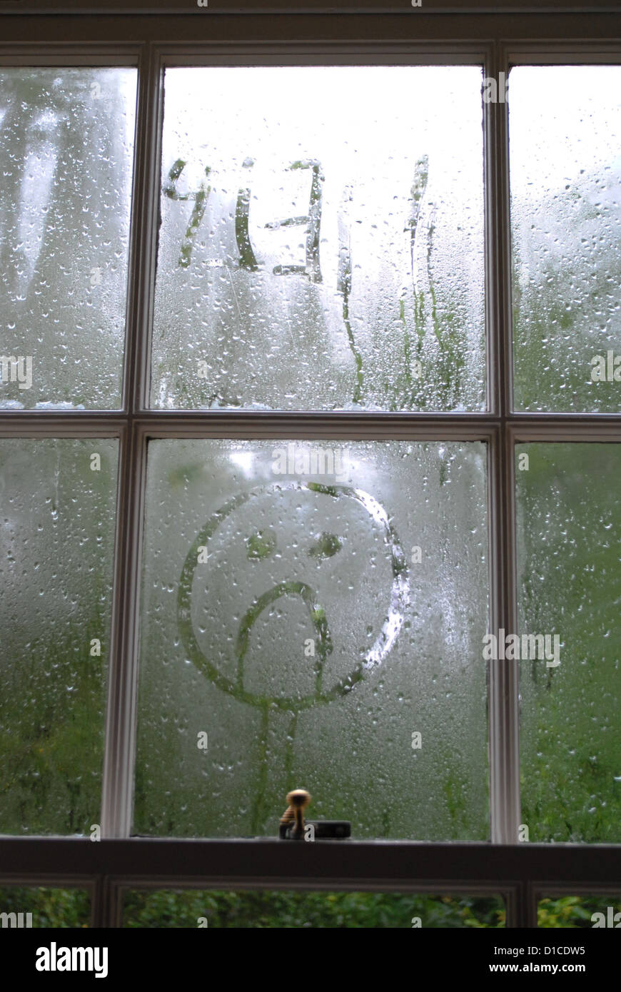 Sad face drawn in window condensation Stock Photo - Alamy