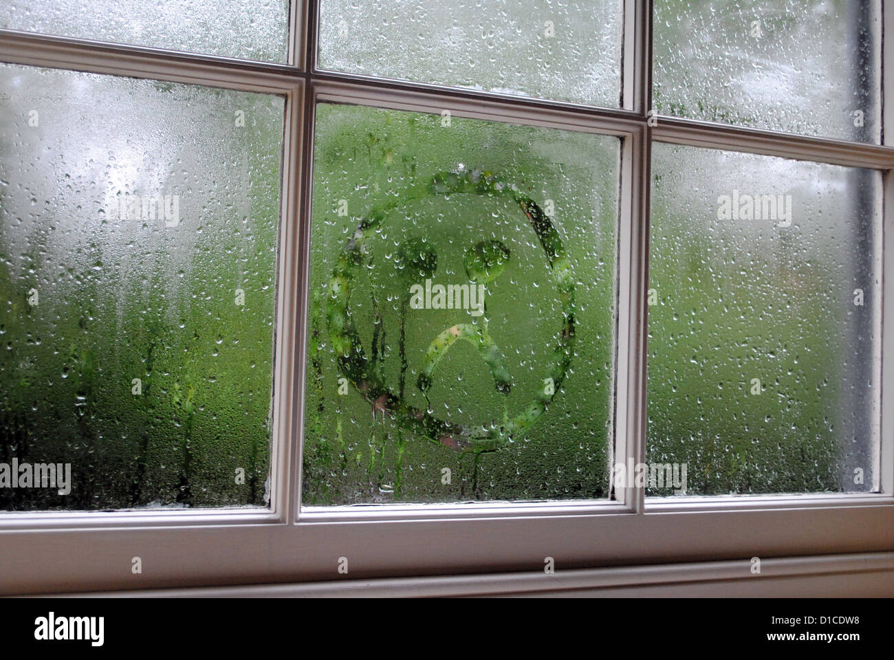 Sad face drawn in window condensation Stock Photo - Alamy
