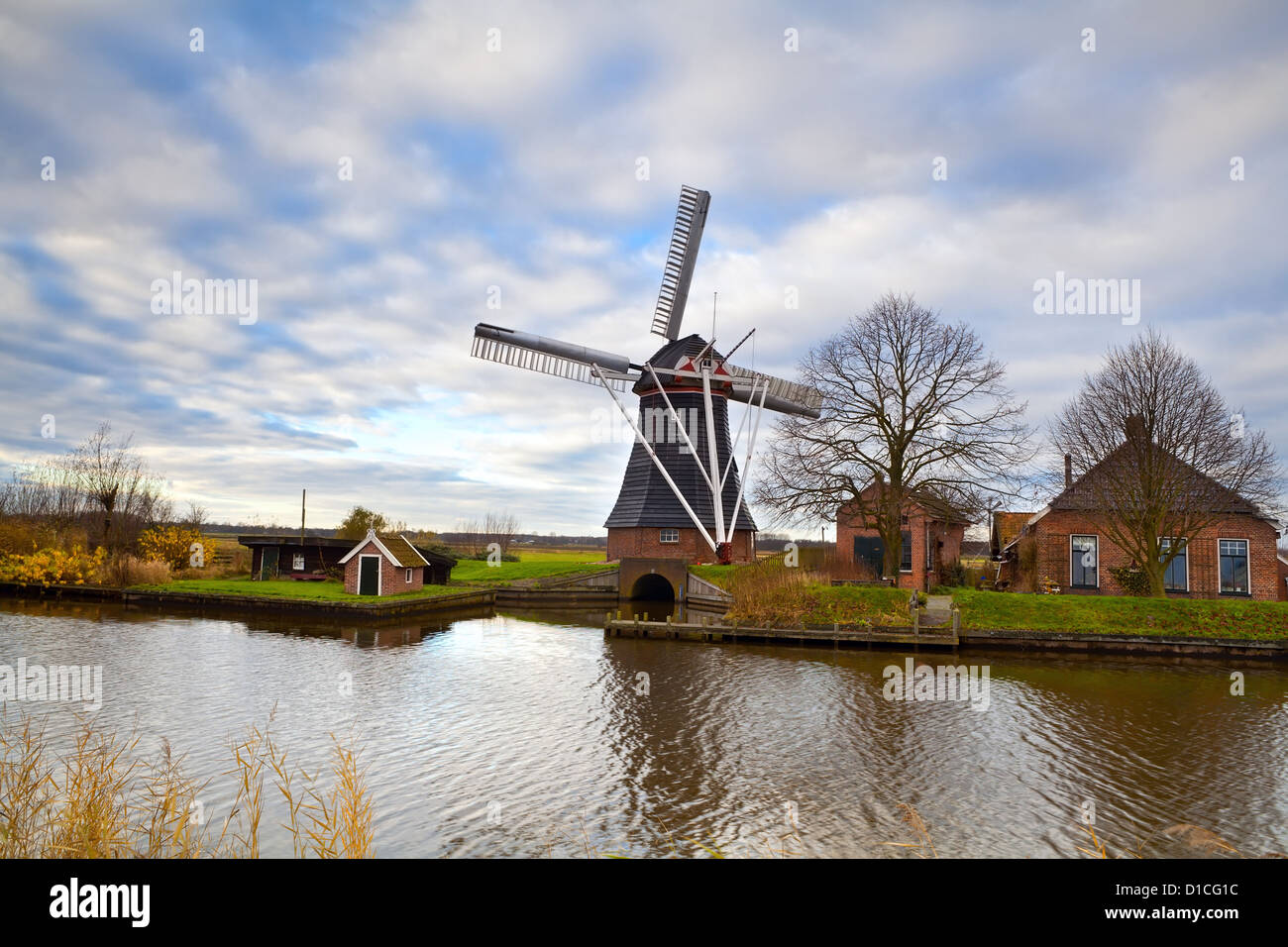 Dutch windmill and farmhouse by canal Stock Photo - Alamy