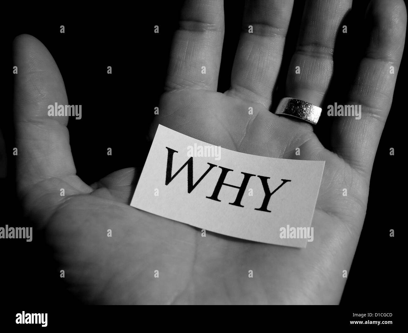 A hand holding WHY sign in the palm with wedding band. MR. ©mak Stock ...