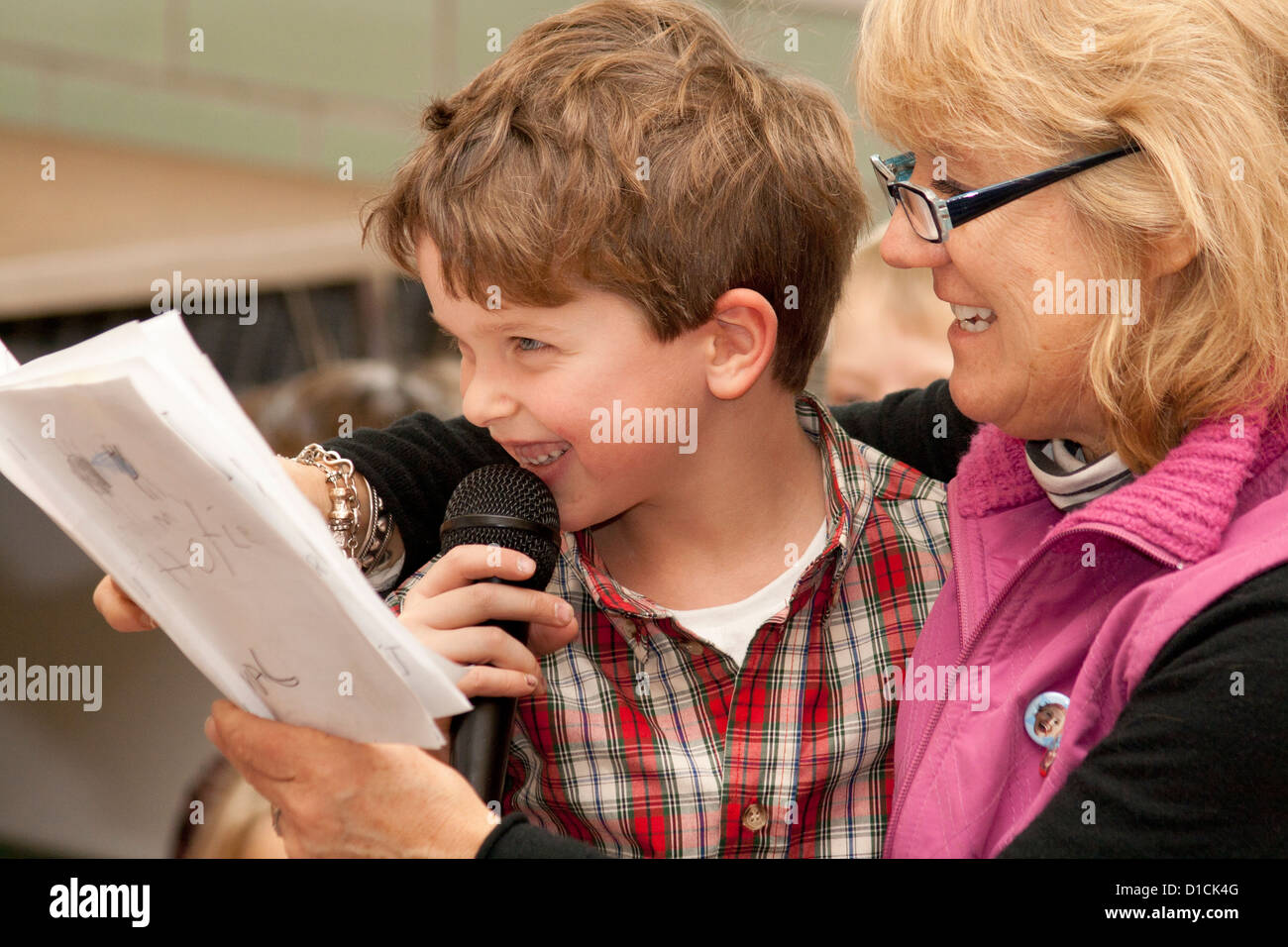 Student age 5 and teacher reading a pamphlet during a classroom ...