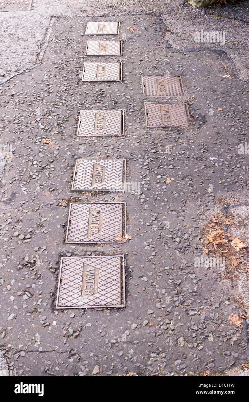 Metal water supply stop cock tap covers in the street UK Stock Photo ...