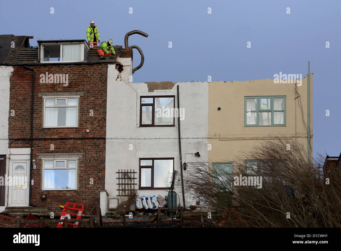 Demolition men slowly and carefully dismantle houses that have been ...
