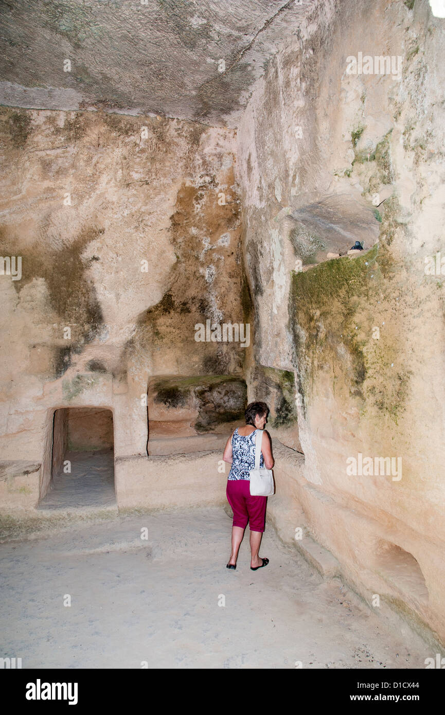 Tourist inside one of the many tombs at the Tombs of the Kings site in ...