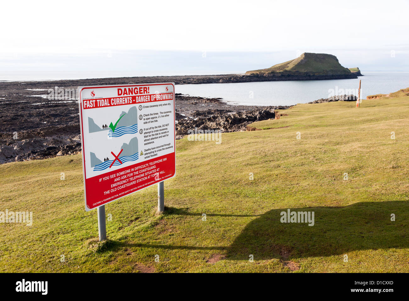 Danger sign warning of fast tidal currents across causeway, Worms Head ...