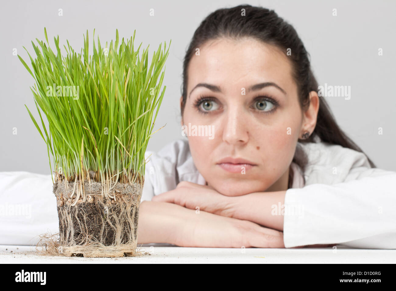 Worried girl watching a plant grow Stock Photo - Alamy