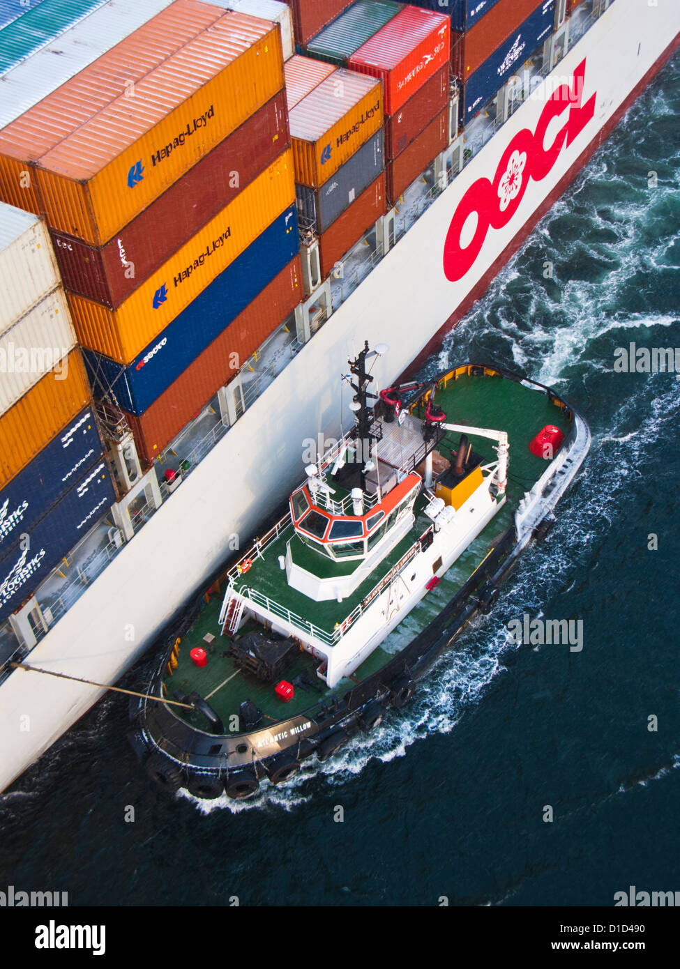 A tug escorts a container ship in Halifax Harbour Stock Photo - Alamy