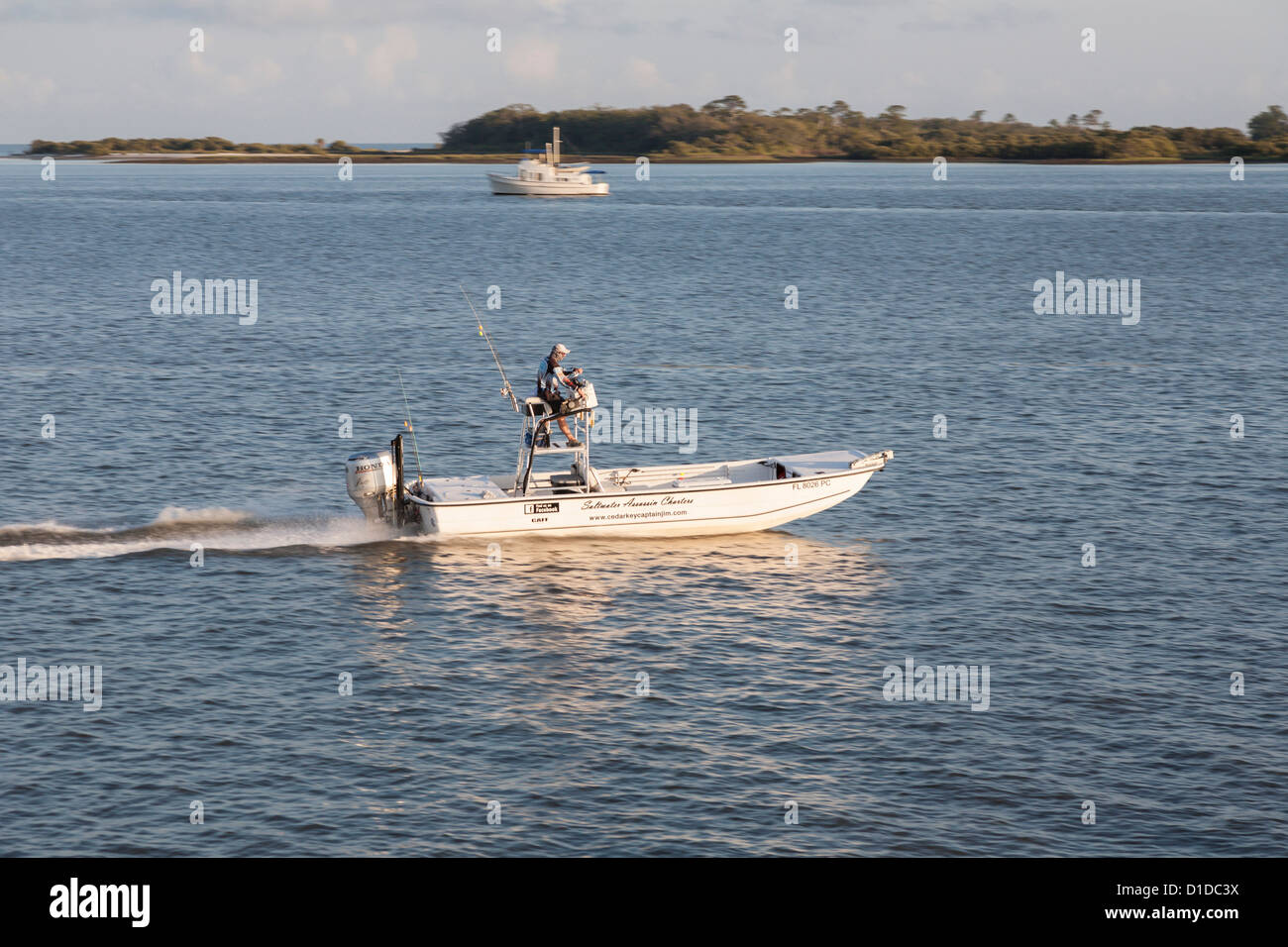 Man driving fishing boat from flying bridge in Gulf of Mexico at Cedar ...