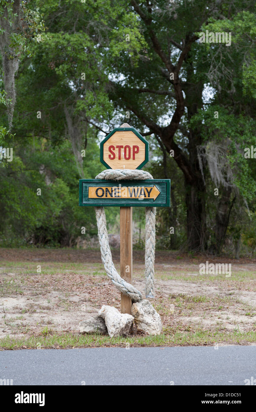 Heavy rope draped over wooden stop and One Way signs on private ...