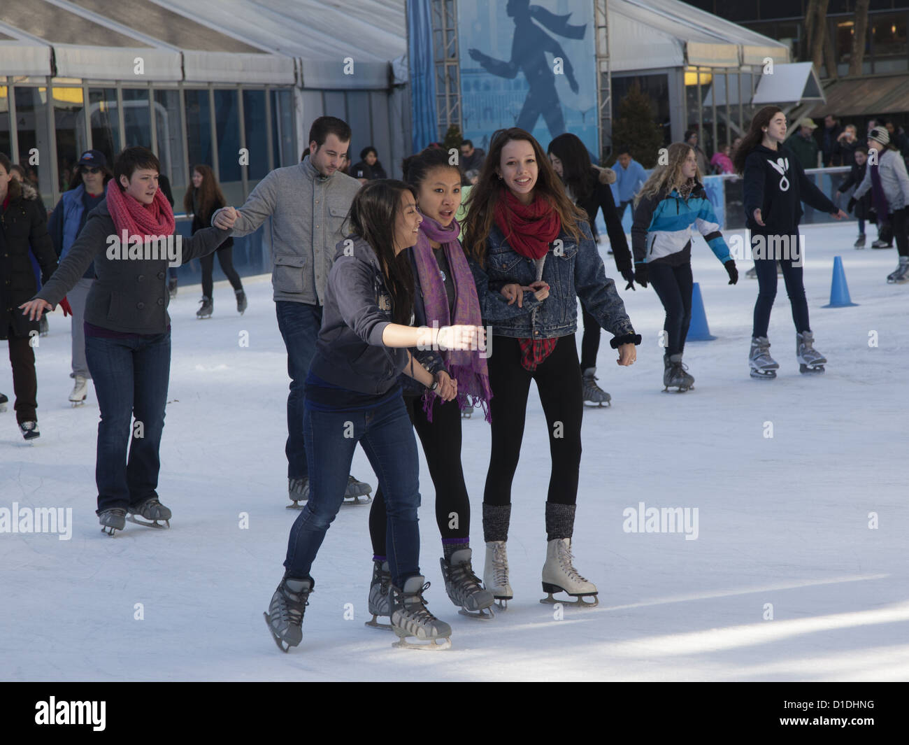 Three young women have fun ice skating together at Bryant Park, New ...