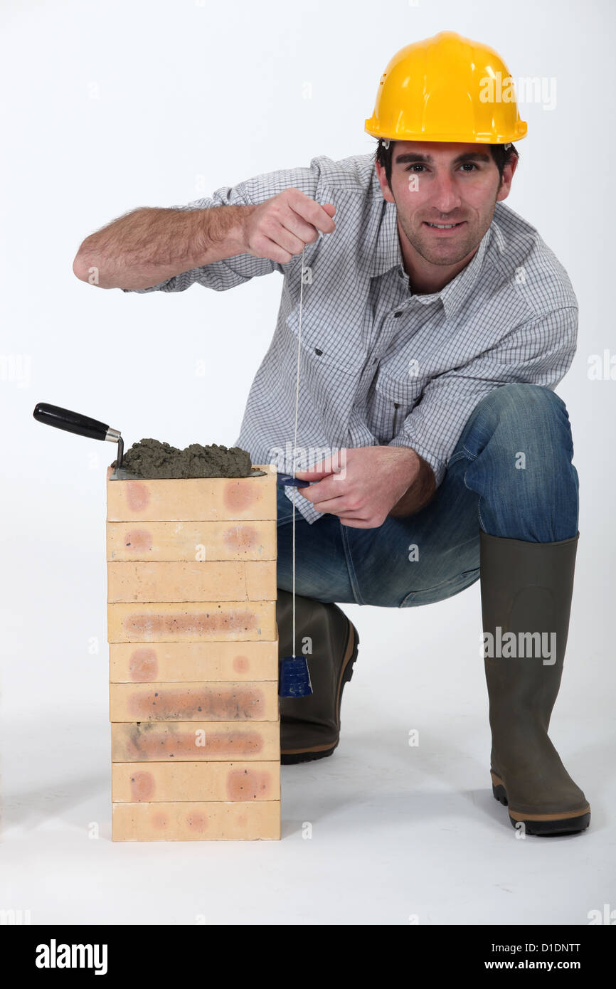 Mason using spirit-level Stock Photo - Alamy