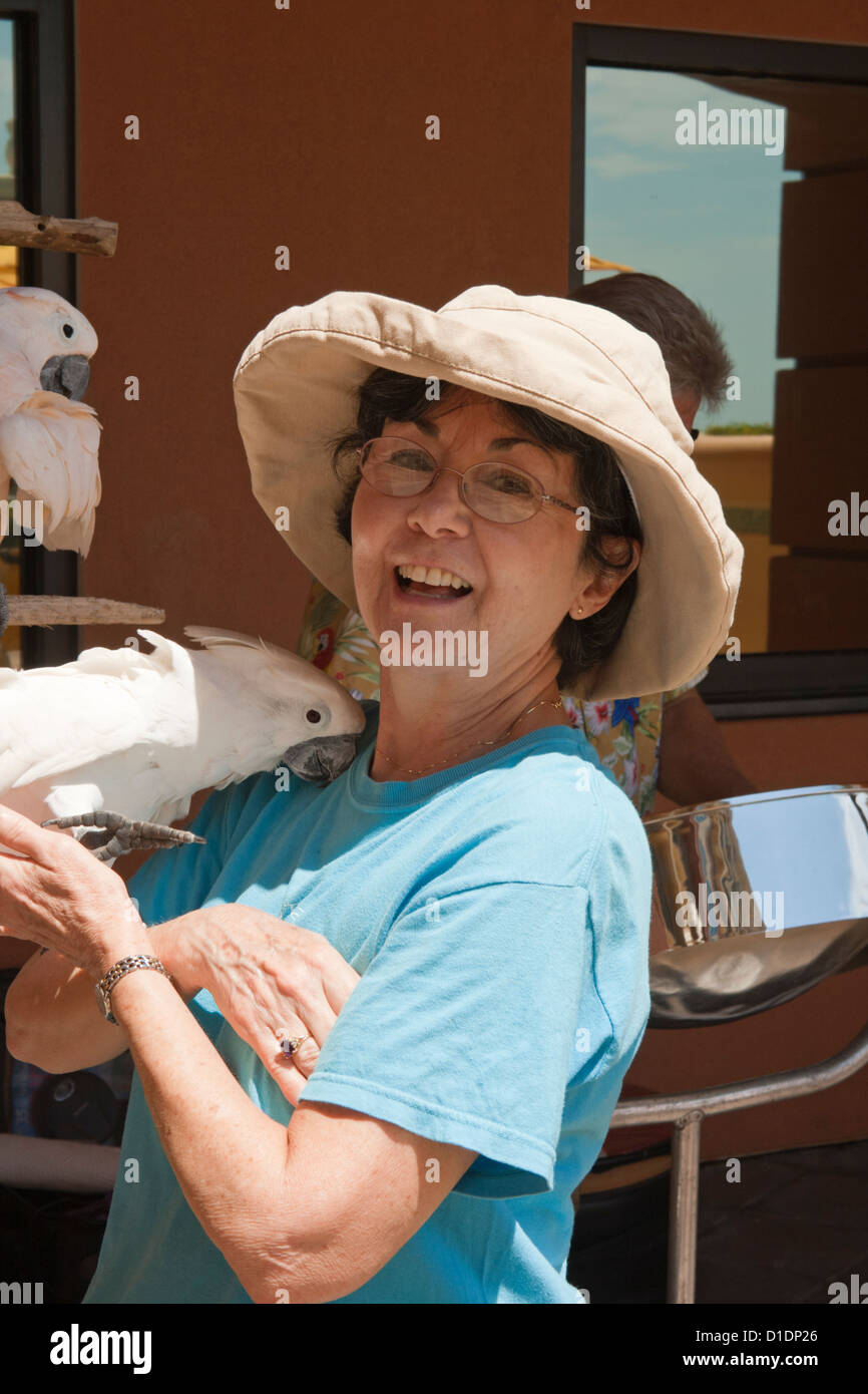 White Parrot gives older lady a kiss on the neck Stock Photo - Alamy