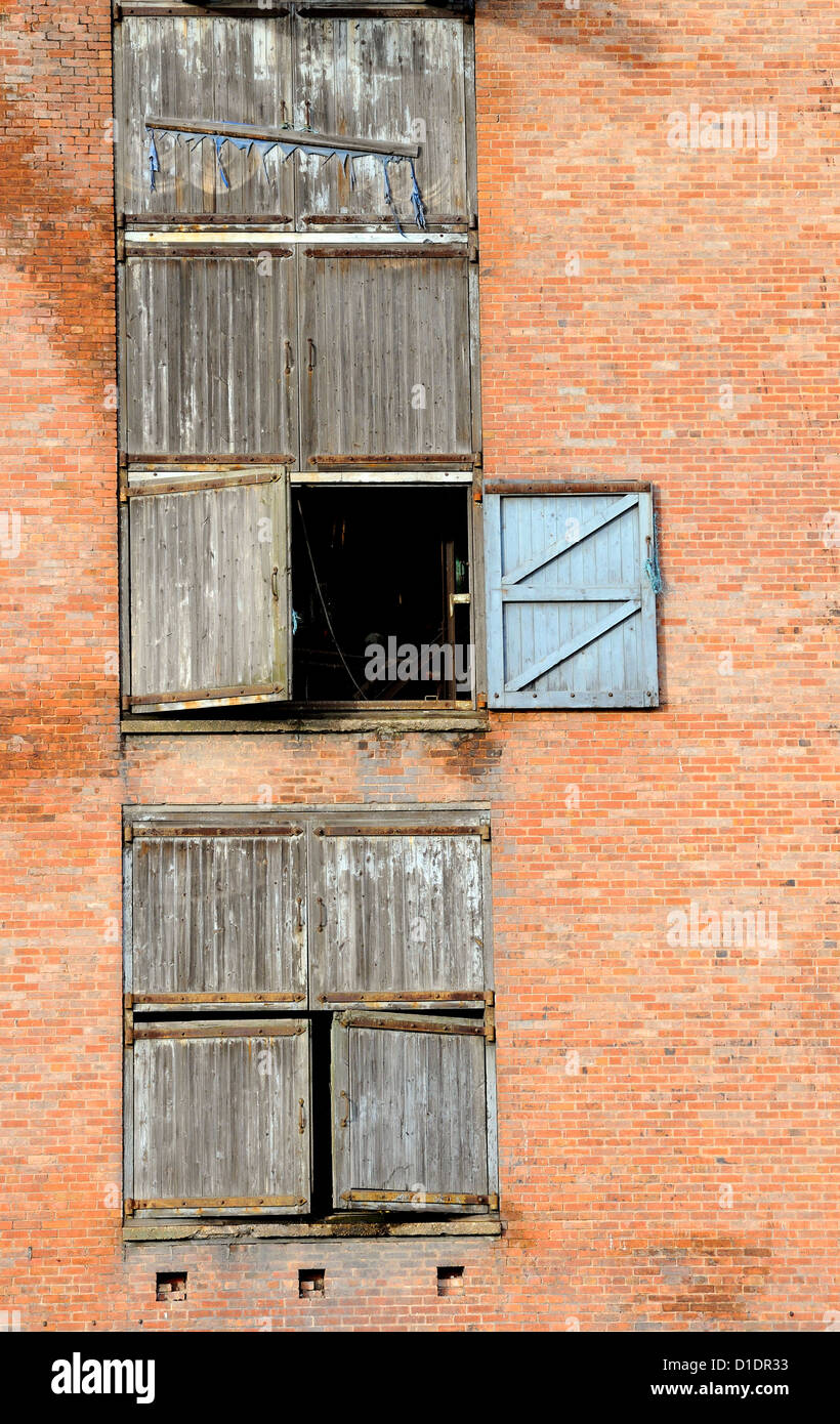Open and closed wooden doors attached to the outside of a disused ...