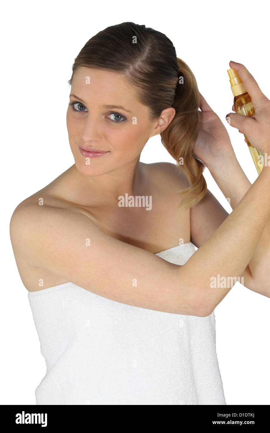 Blond woman using hair spray Stock Photo - Alamy