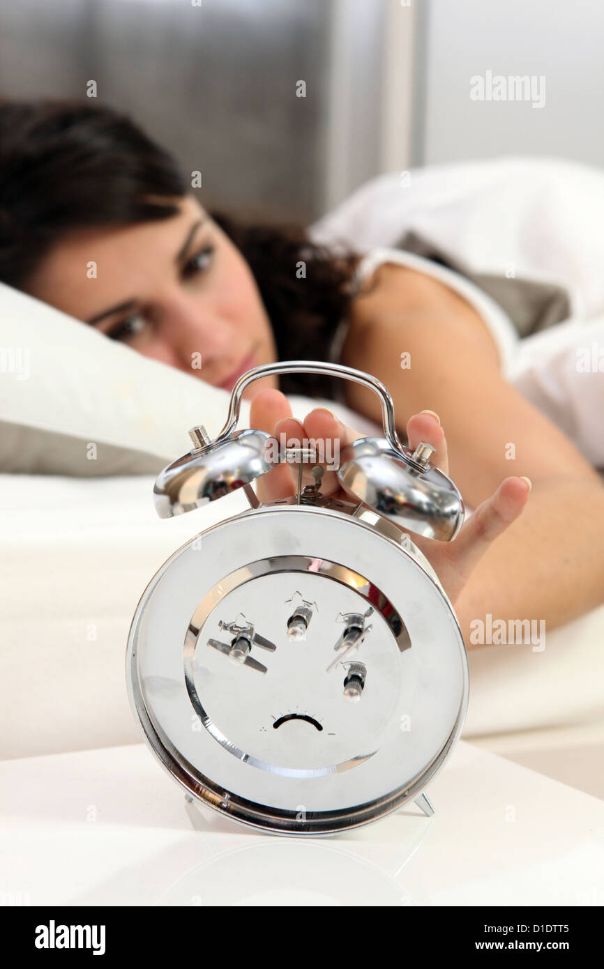 Woman turning off alarm Stock Photo - Alamy