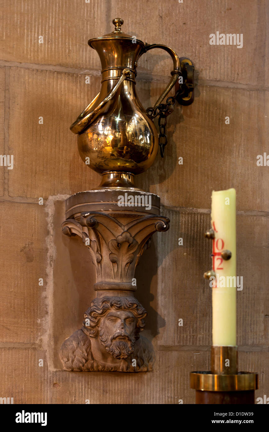 Holly water and a candle in a church Stock Photo - Alamy