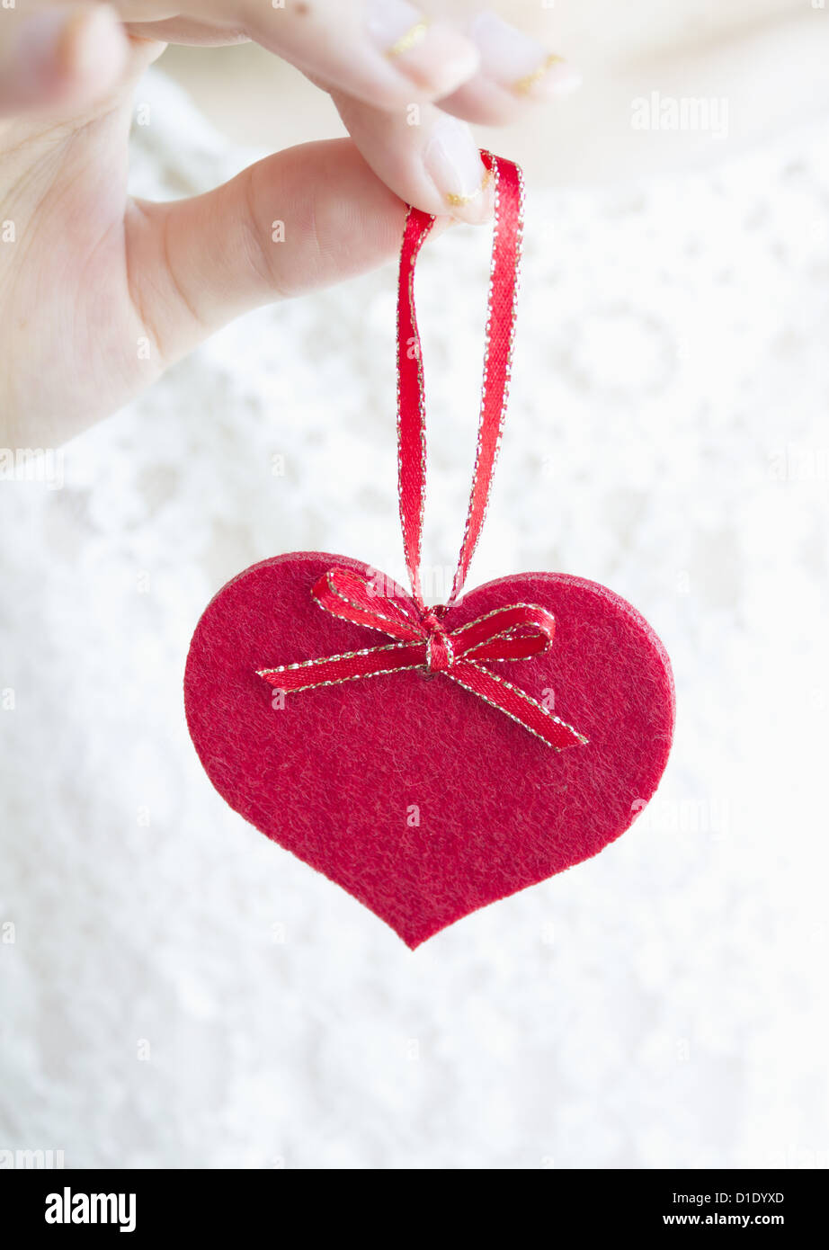 Hand holding a heart-shaped ornament Stock Photo - Alamy