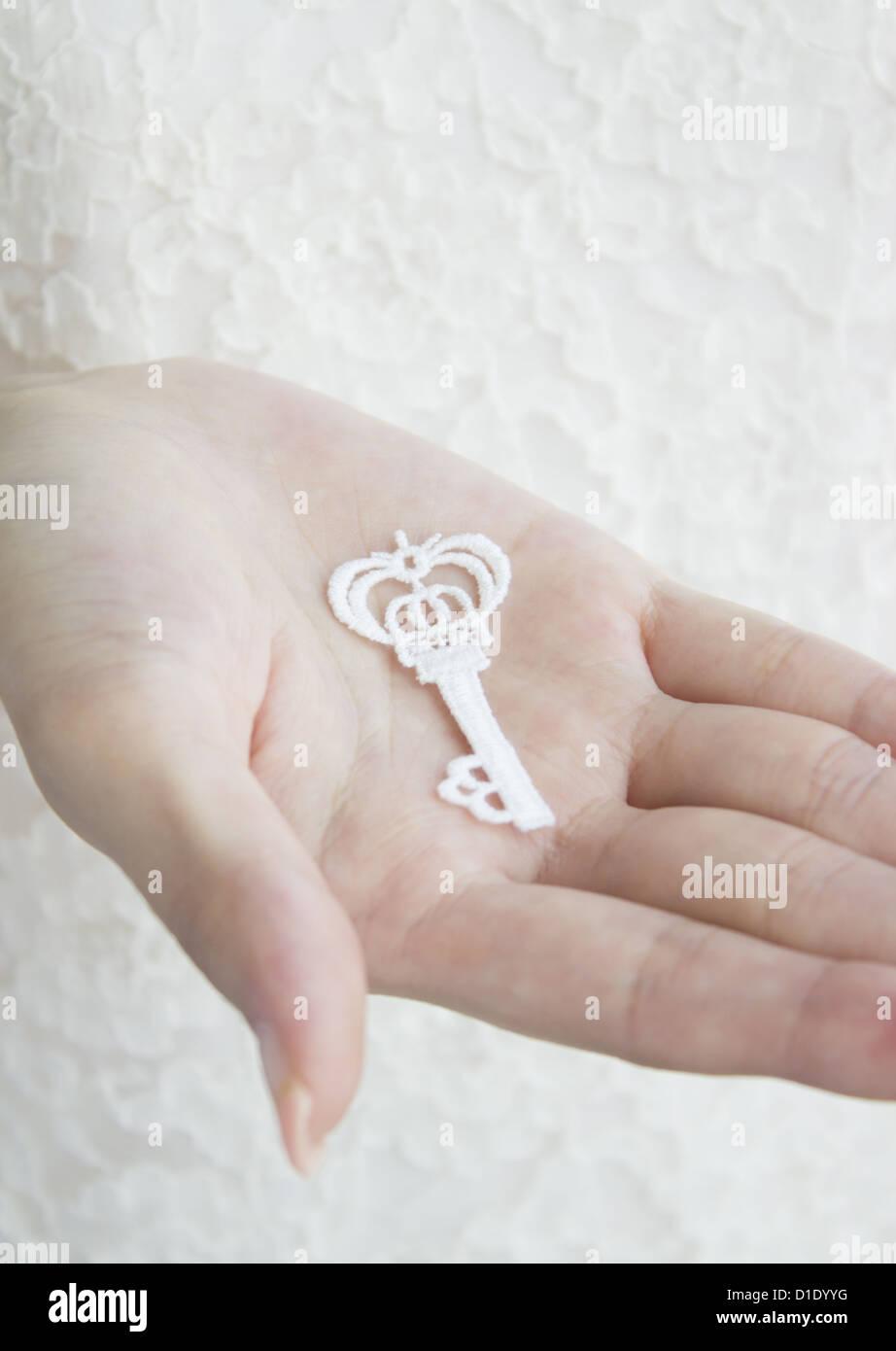 Hand holding key-shaped lace Stock Photo - Alamy