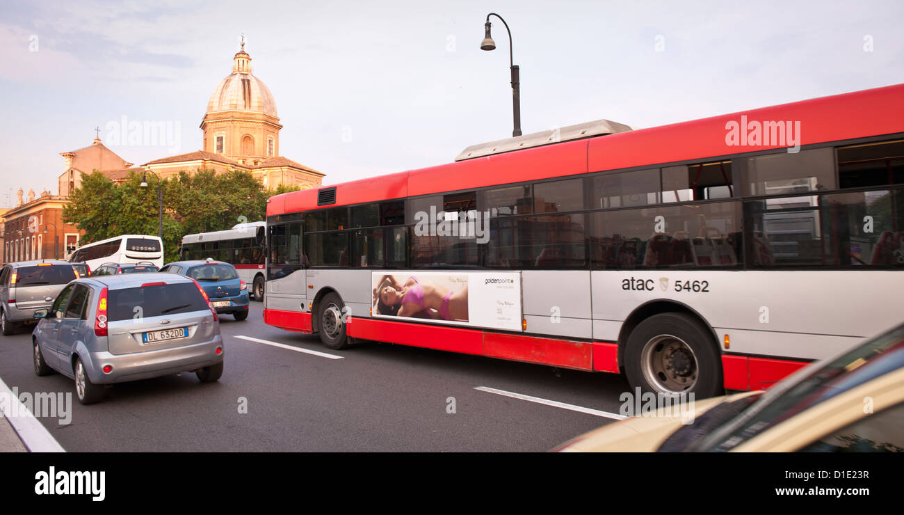 Commuter bus crossing a bridge over the River Tiber with St John of the ...