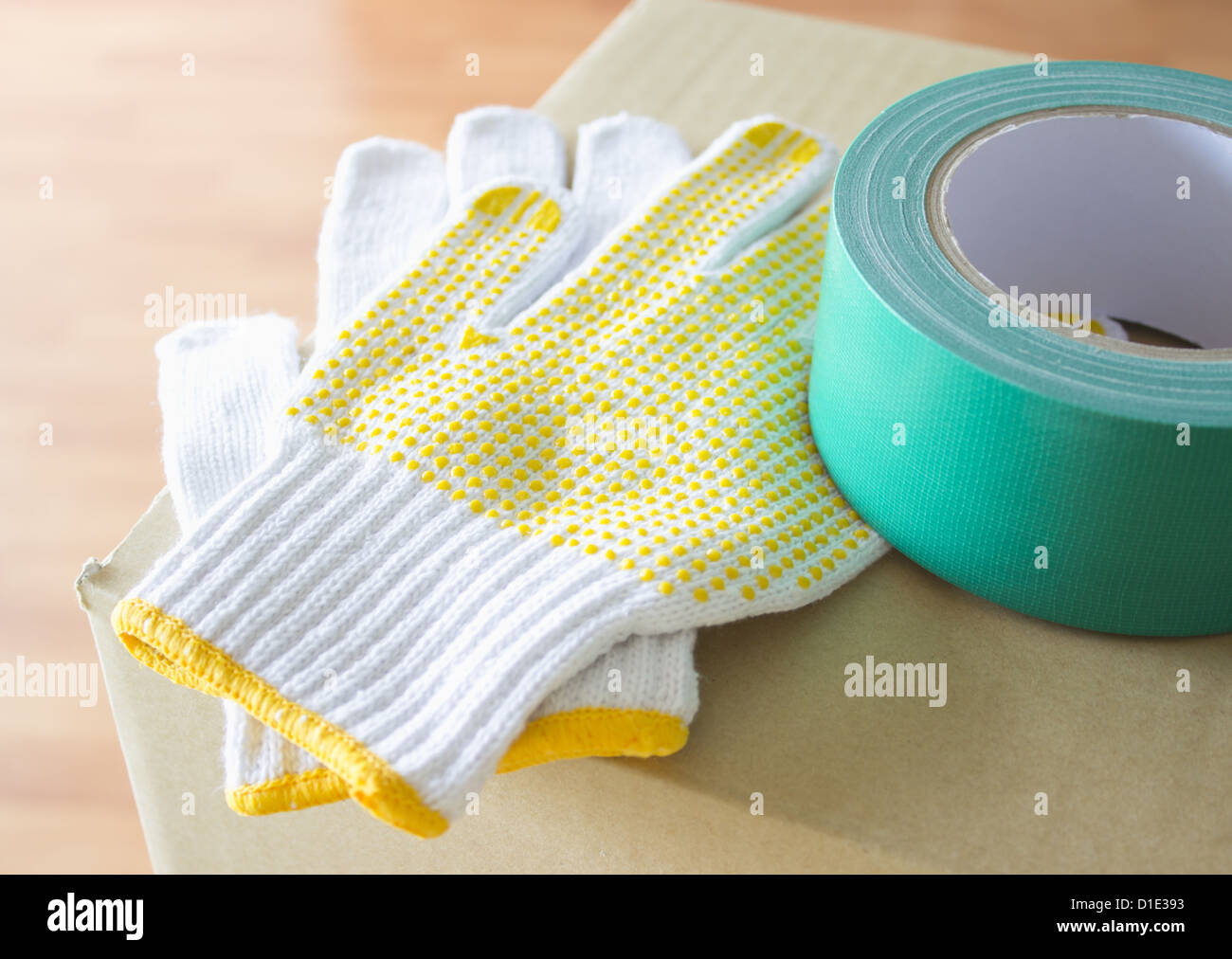 Work gloves and a packing tape on a cardboard box Stock Photo - Alamy
