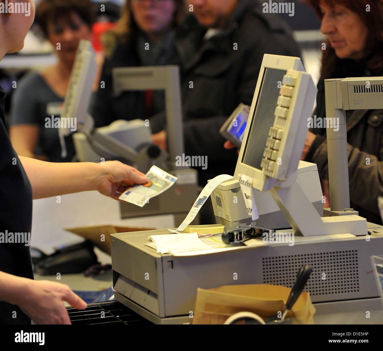 Customers stand in front of a cash register in a shop in Munich ...