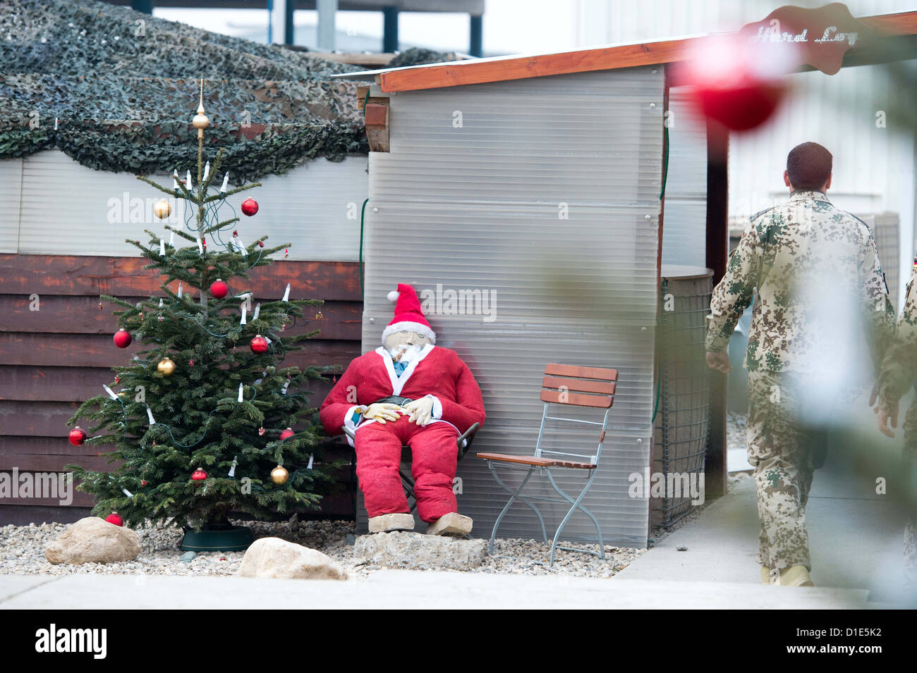 German soldiers walk by a decorated Christmas tree in the Camp Marmal ...