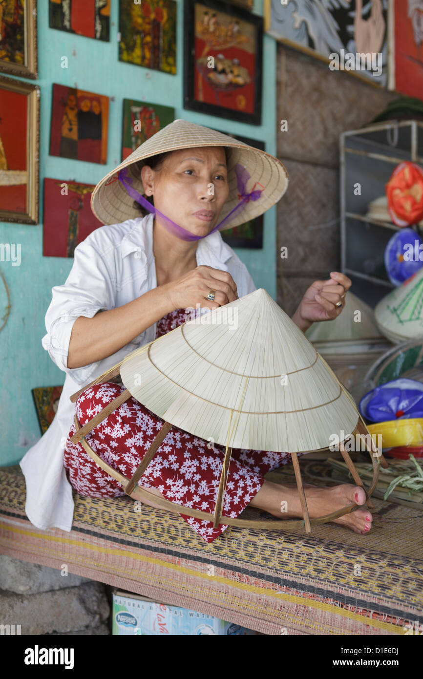 A women weaves a conical hat at a crafts village, Hue, Vietnam ...