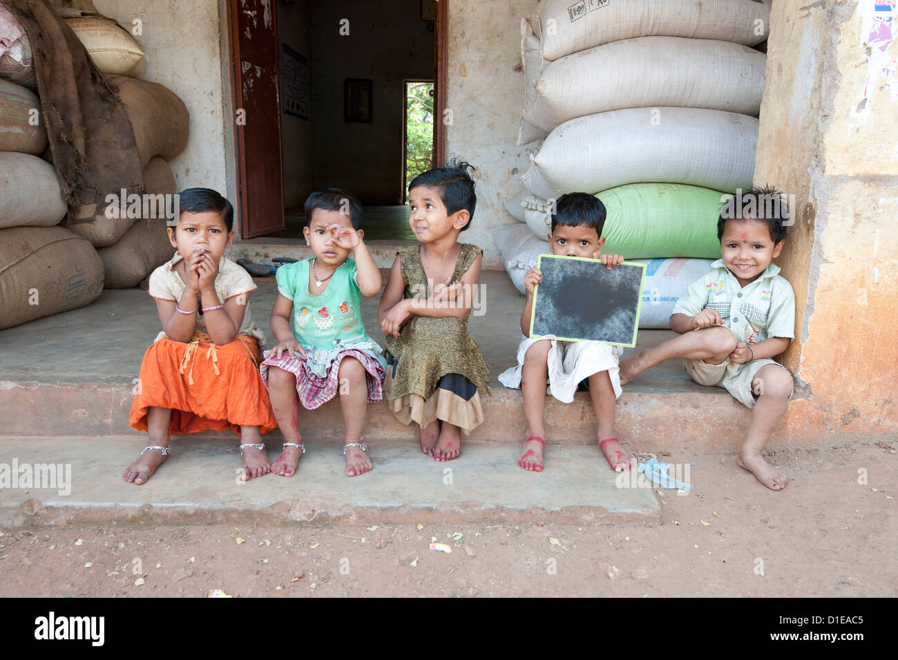 Untouchable village children sitting outside their house in brassmaking ...