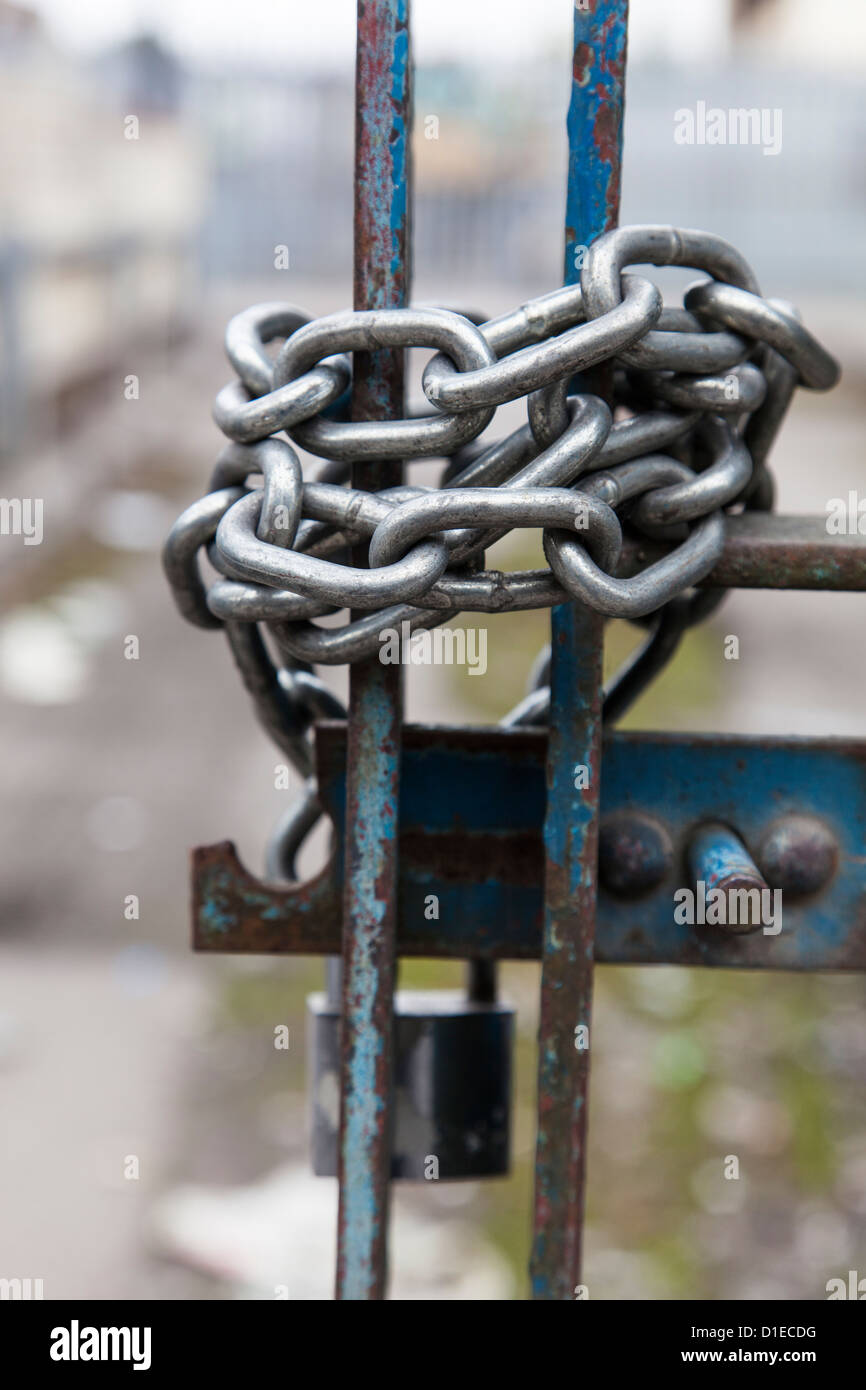Close-up of a steel linked chain with padlock on a metal gate Stock ...