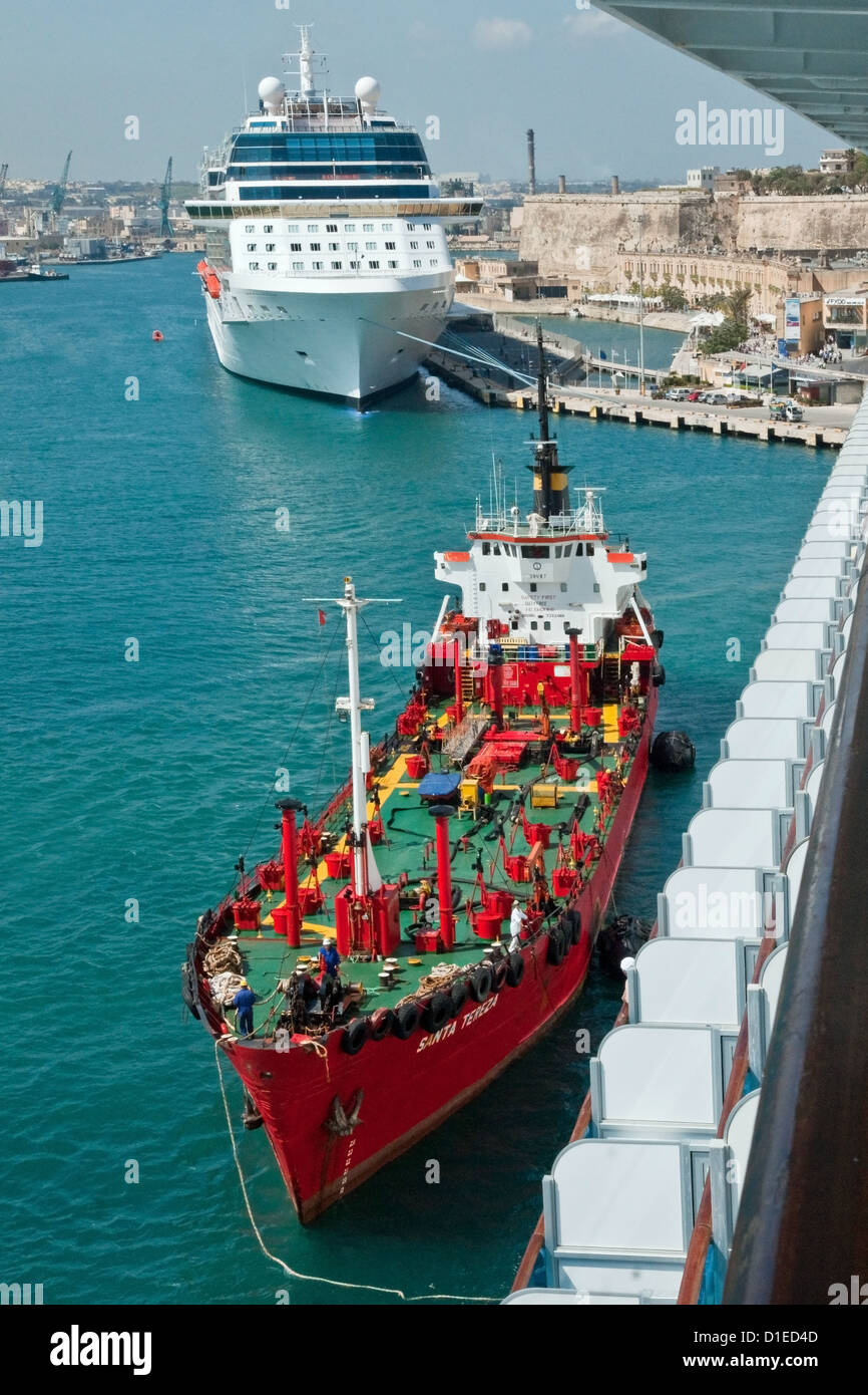 Refuelling tanker comes alongside a newly-arrived cruise ship in Grand ...