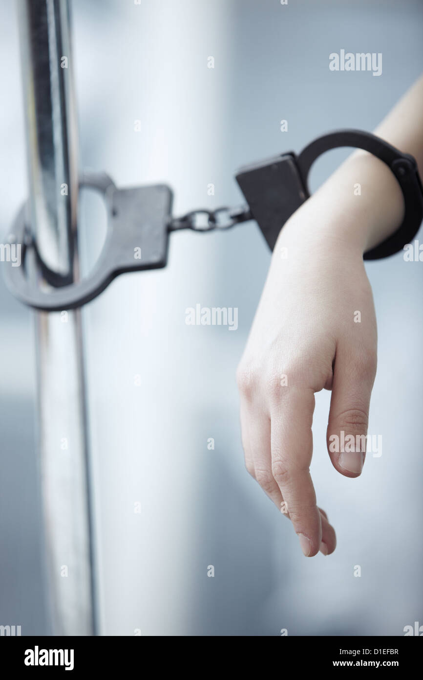 Human hand bounded to the metal pole by handcuffs Stock Photo - Alamy