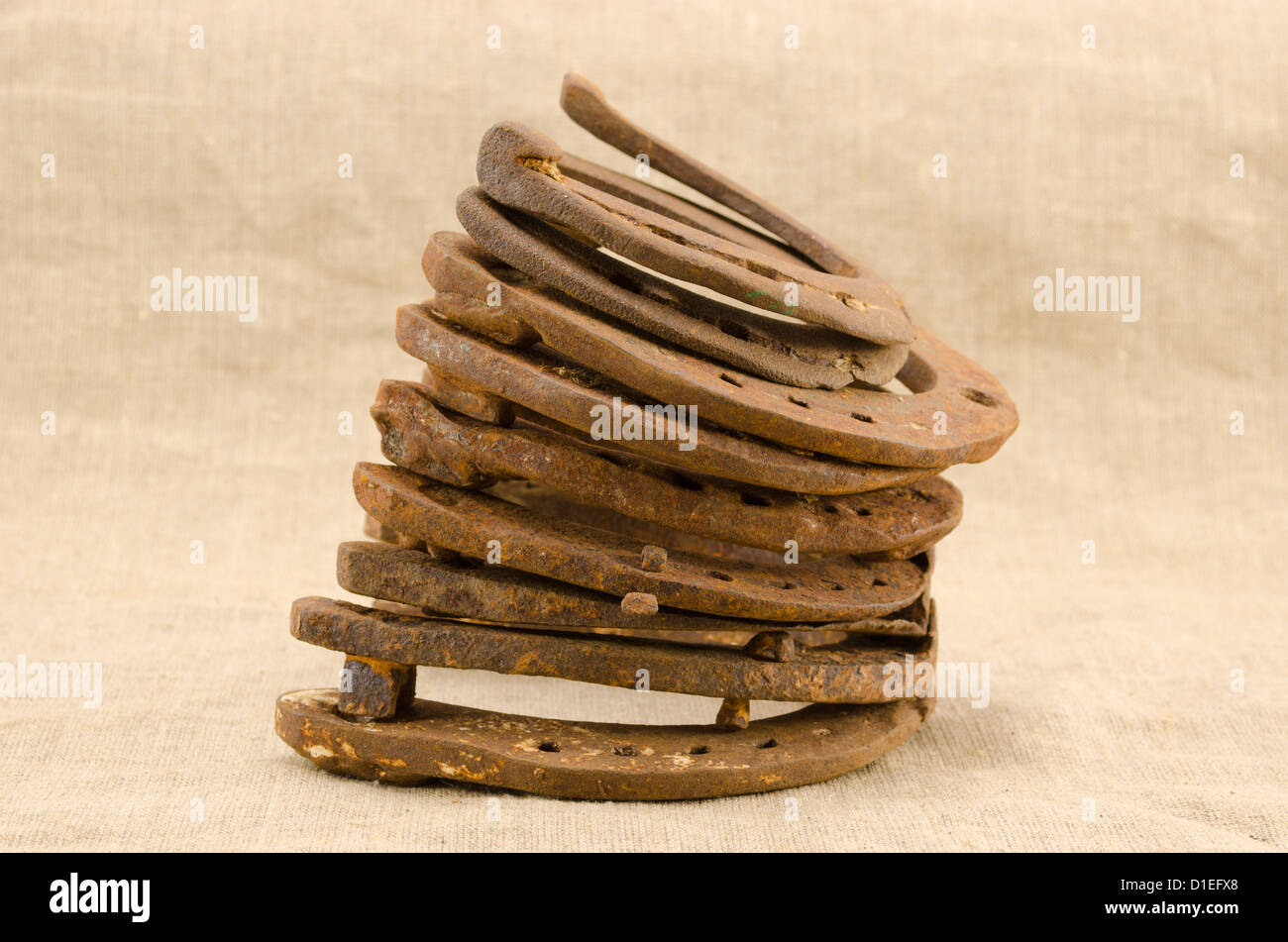 stack of old retro horse shoes isolated on linen material background ...