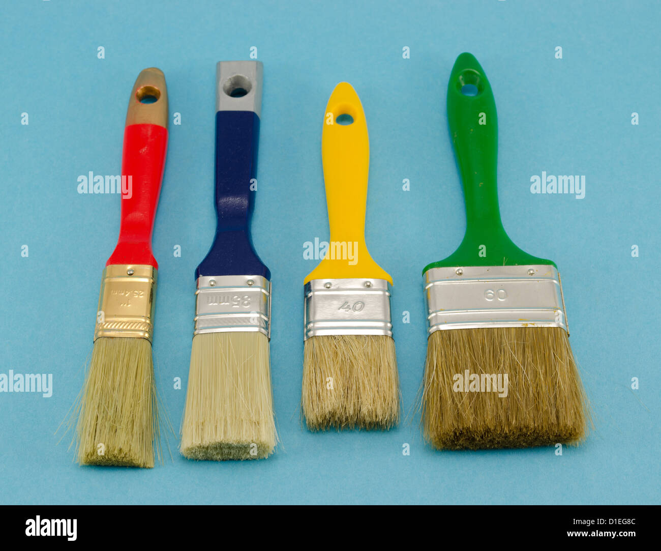 different colors and size paint brushes on blue background Stock Photo ...