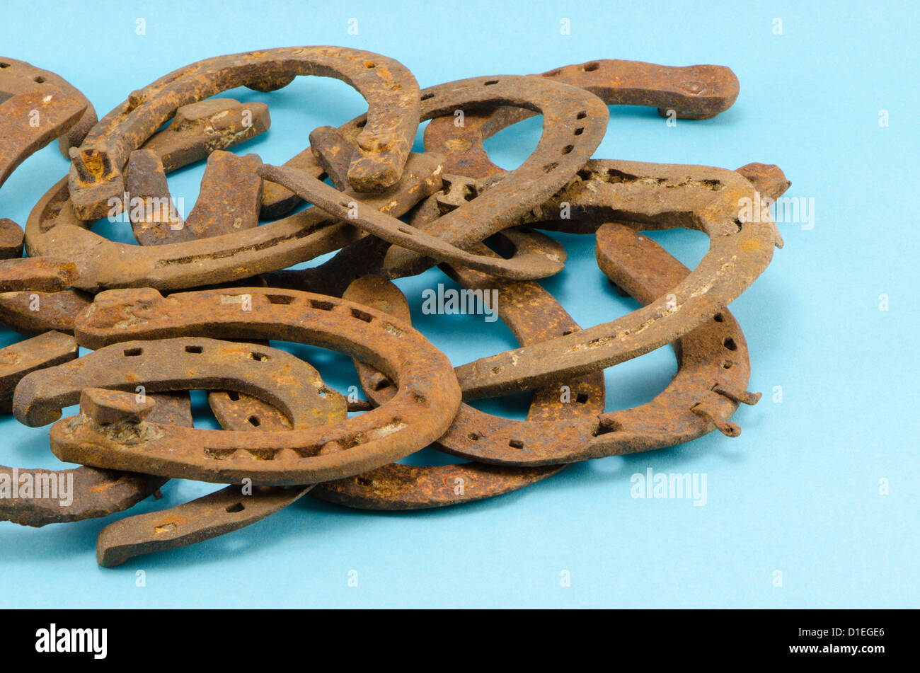 stack of old retro horse shoes on blue background Stock Photo - Alamy