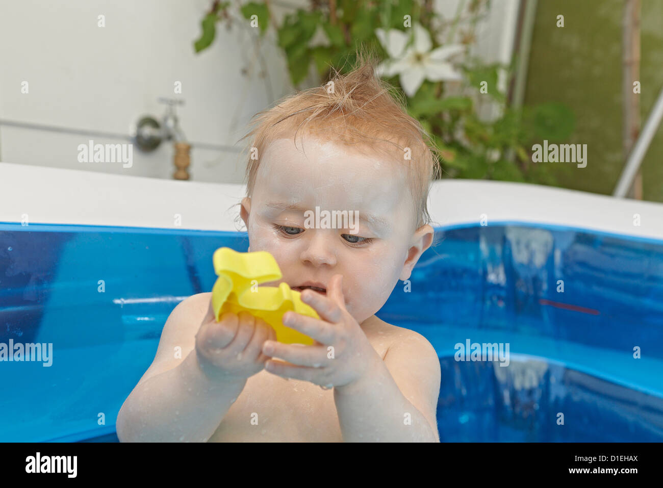 Female baby sitting in paddling pool Stock Photo - Alamy