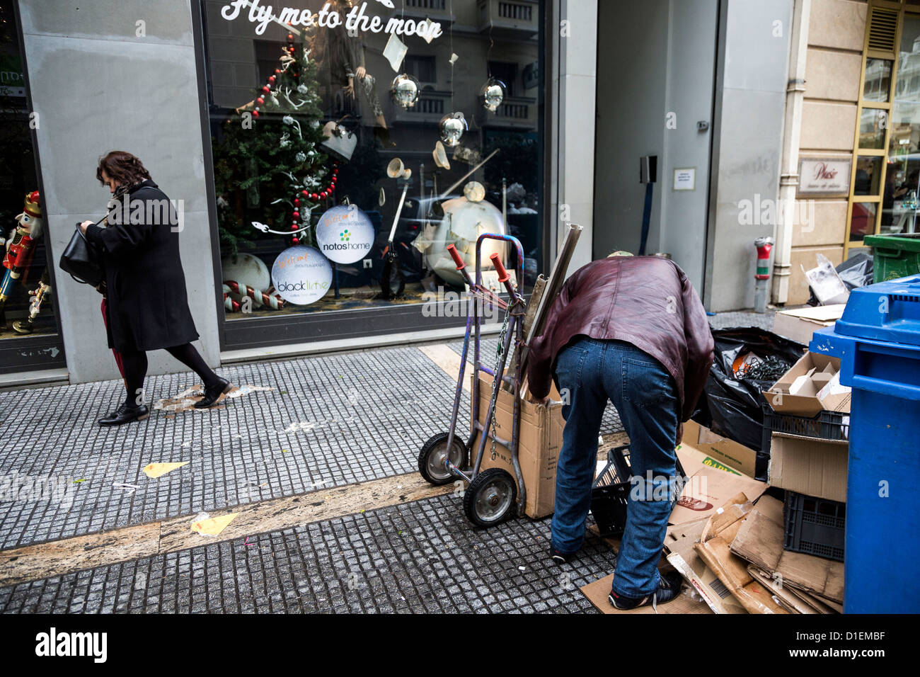 A man is looking in the garbage in front of the department store ...