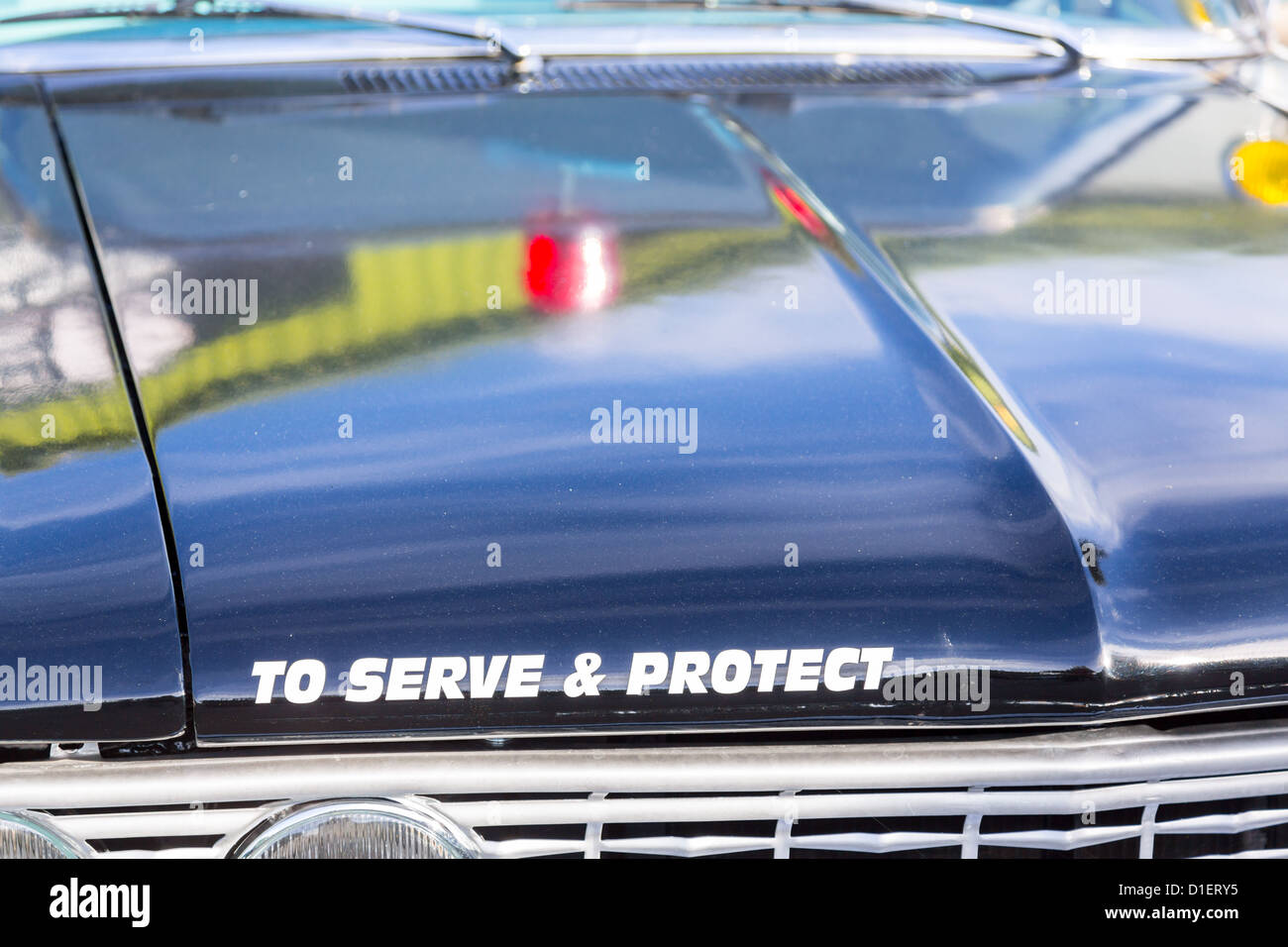 Vintage police car with detail focus on hood and reflections of warning ...