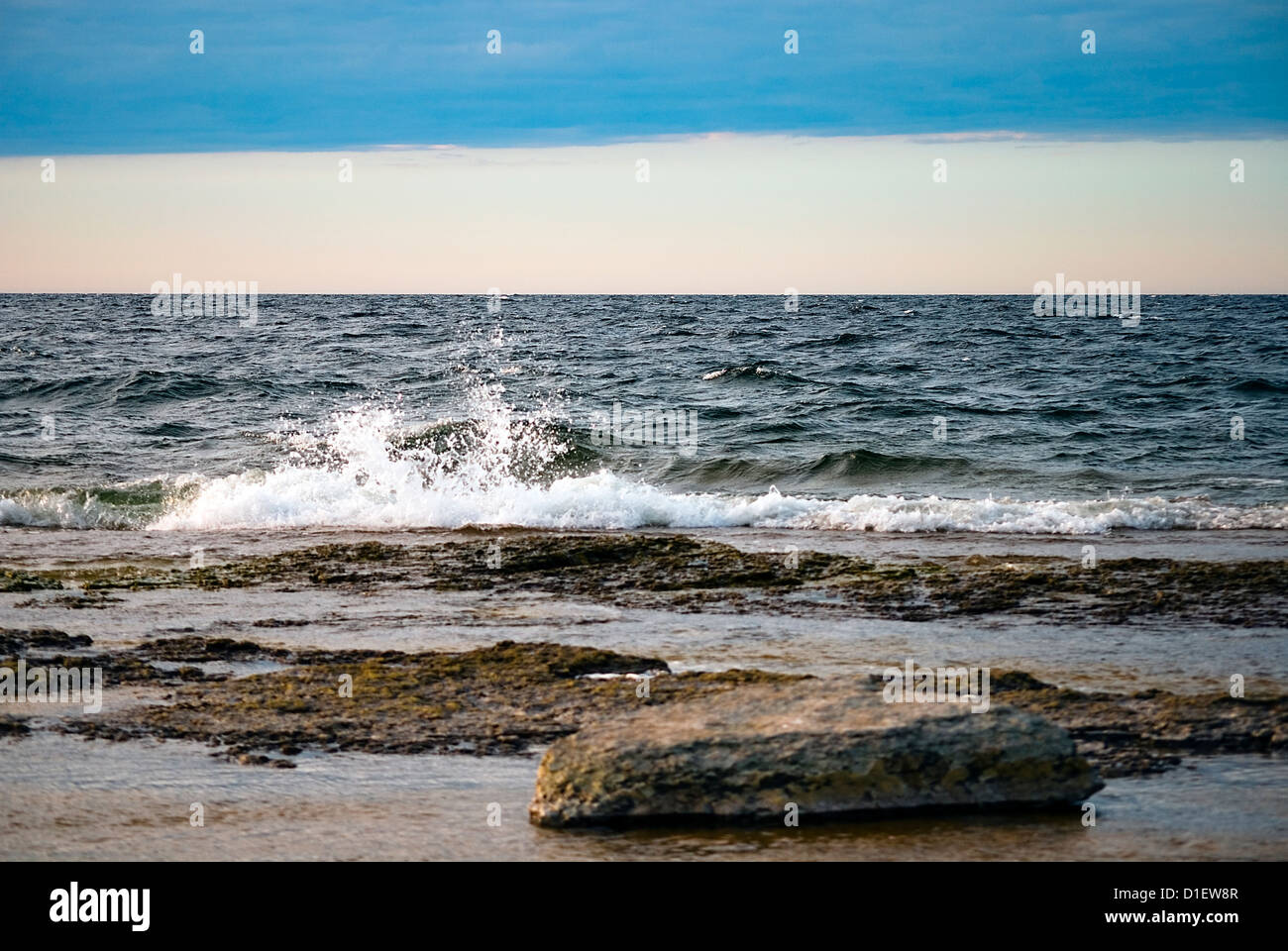 Wave splash over rocky coast and beautiful blue sky Stock Photo - Alamy
