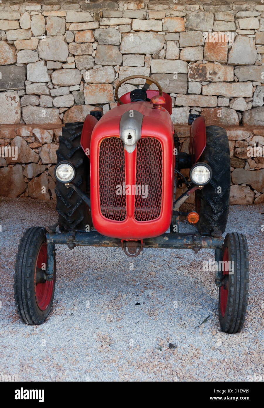 Antique red rusty tractor against stone wall Stock Photo - Alamy