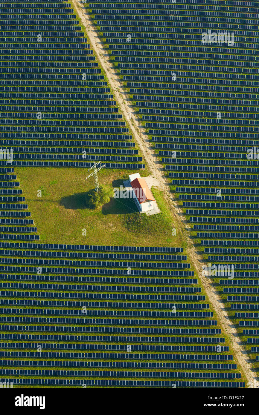 Solar panels, house and electricity pylon on a field, aerial photo ...