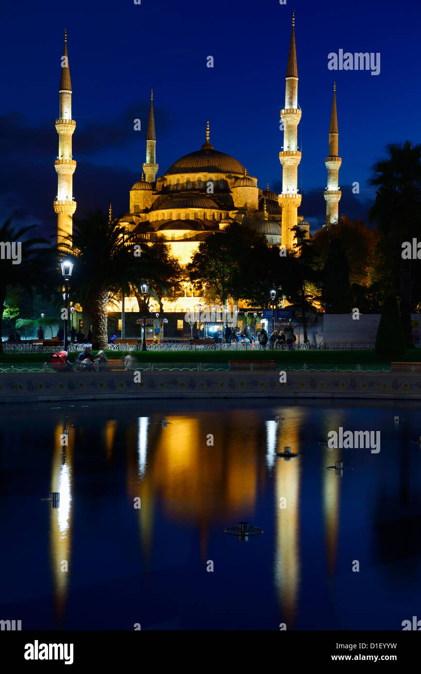 Gold lights on Blue Mosque at indigo dusk with reflections in fountain ...