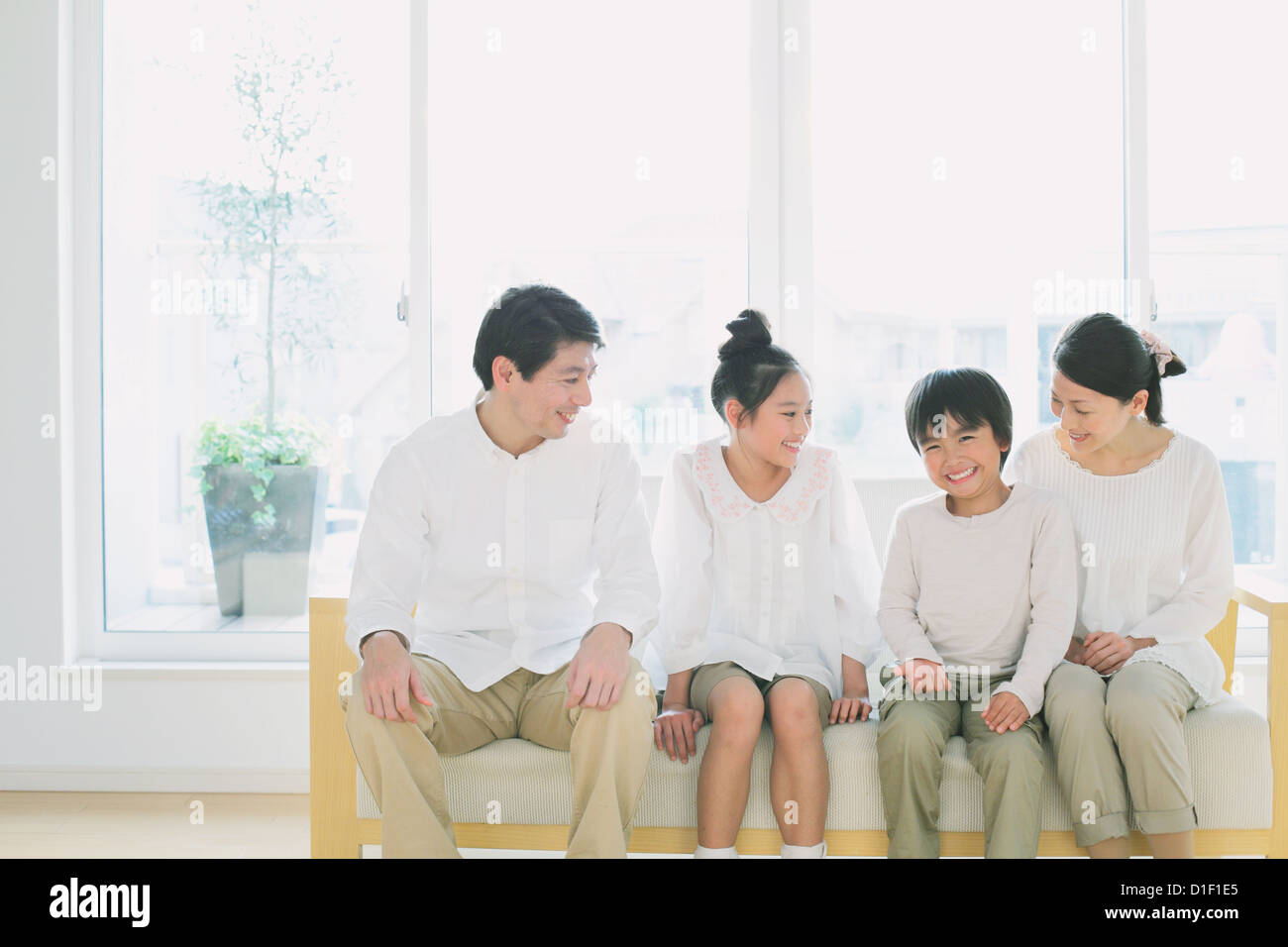 Family of four people smiling on the sofa Stock Photo - Alamy
