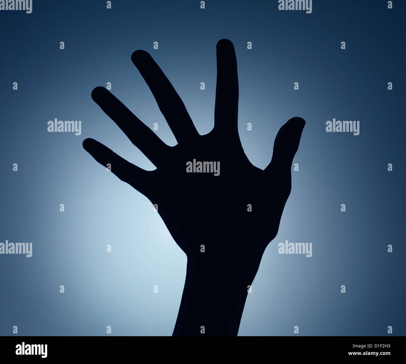 hand silhouette with fingers spread backlit on blue gradient background ...