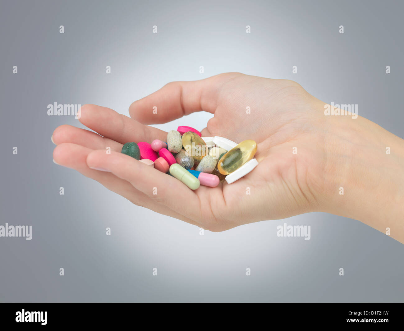 handful of pills with neutral gray gradient background Stock Photo - Alamy
