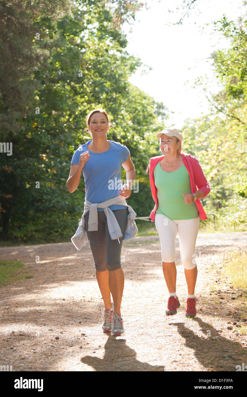 Two women jogging on forest path Stock Photo - Alamy
