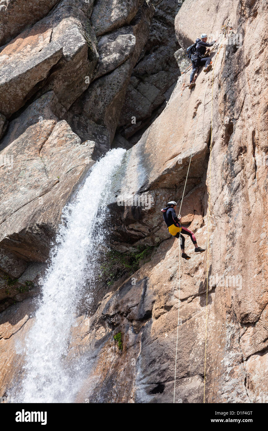 People abseiling at rock face, Cascade de Piscia di Gallo, Corsica ...