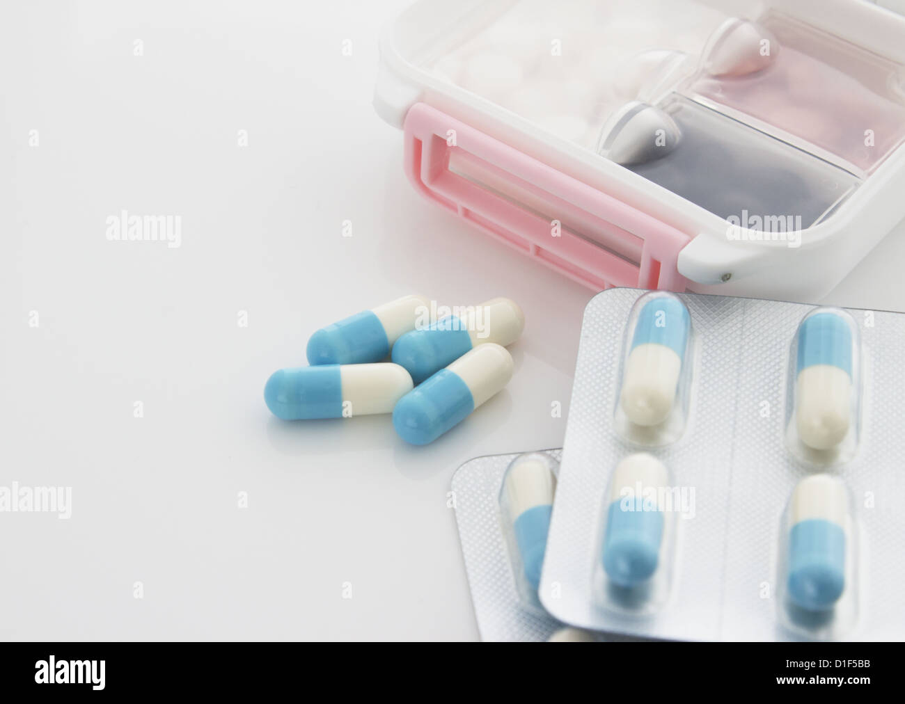 Capsules and a pill case Stock Photo - Alamy