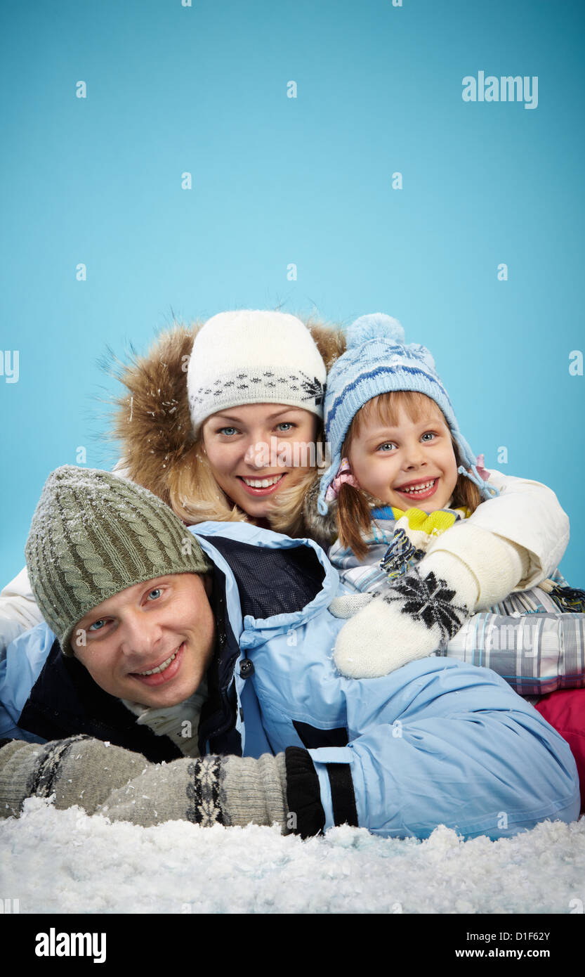 Happy parents and their daughter in winterwear lying in snow Stock ...