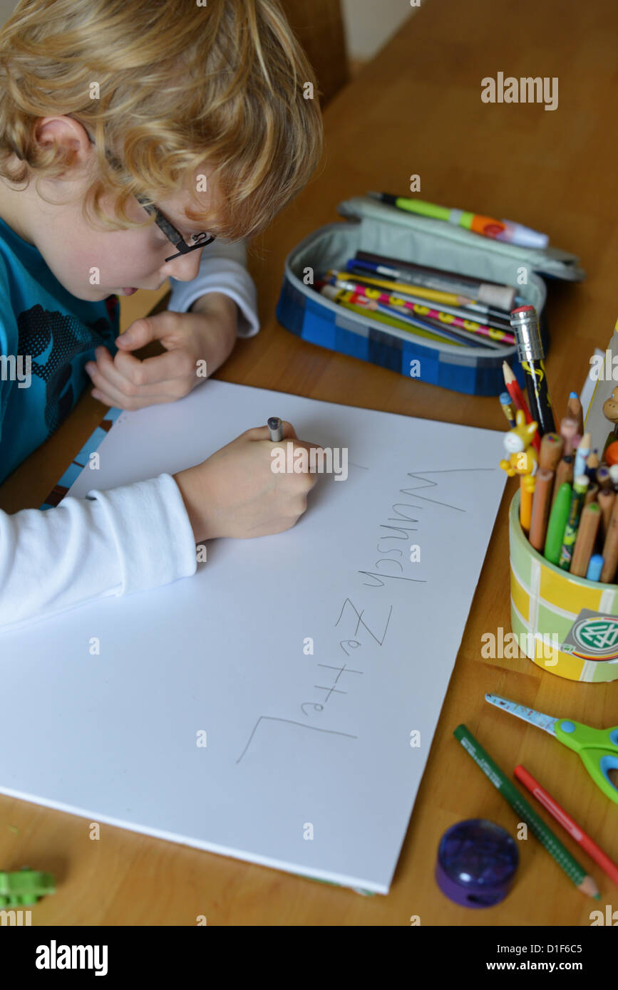 A young boy is writing a list of wishes for Christmas Stock Photo - Alamy