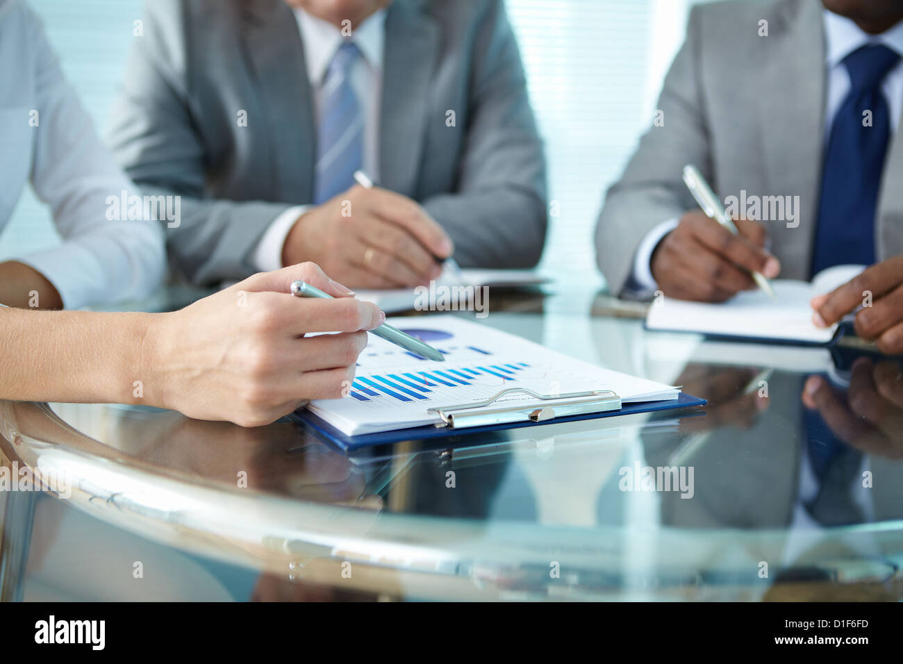 Close-up of human hand with pen pointing at paper while explaining ...